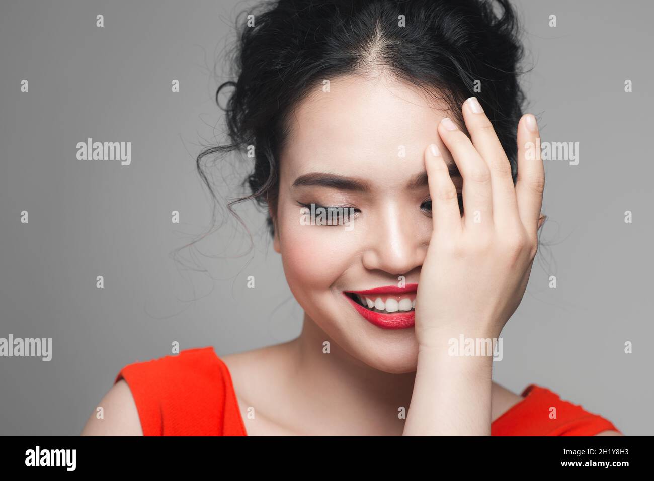 Glamorous stylish woman in evening make-up, covers half of her face ...