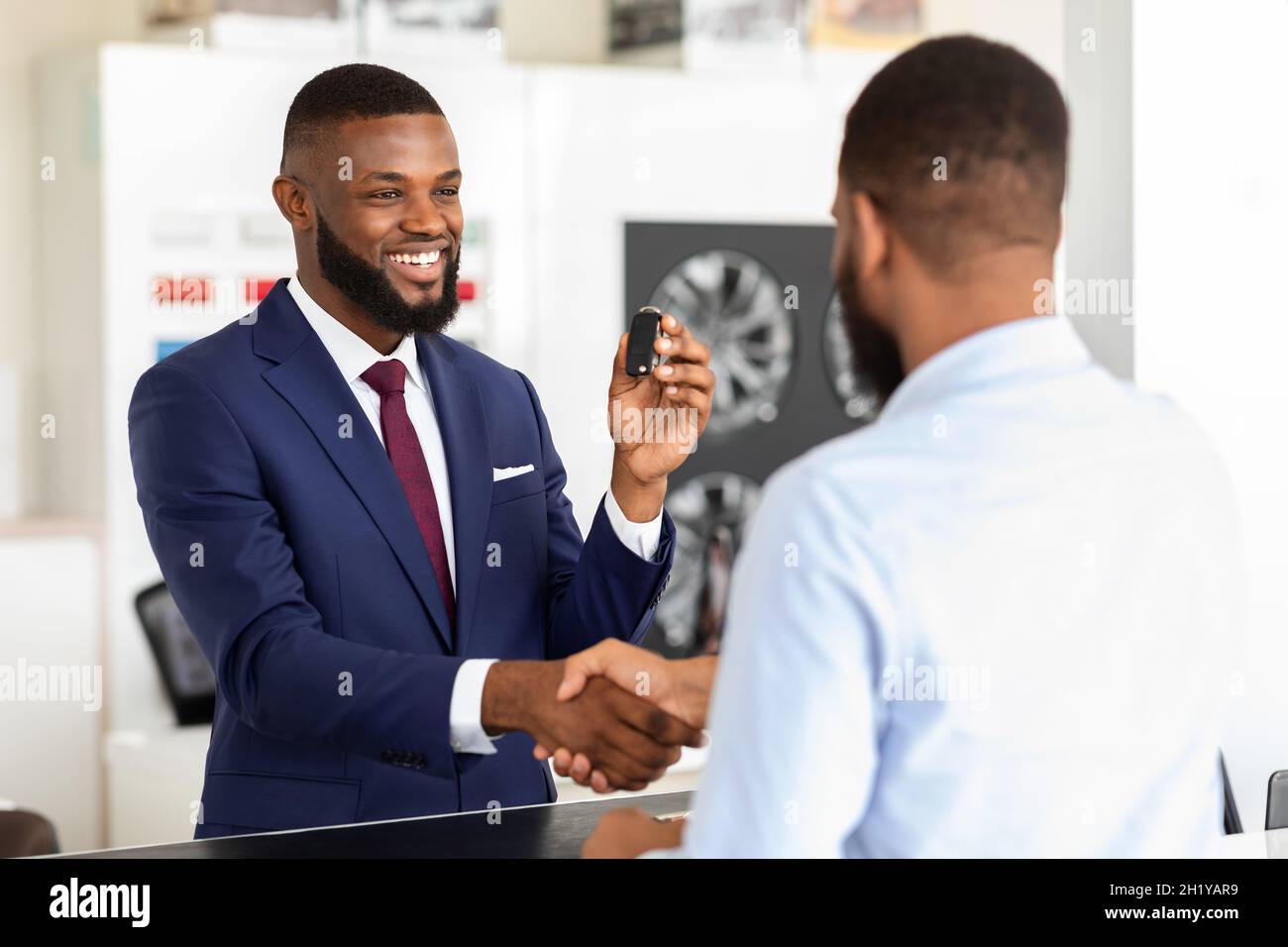 Black Salesman And Male Customer Shaking Hands After Deal In Dealership ...