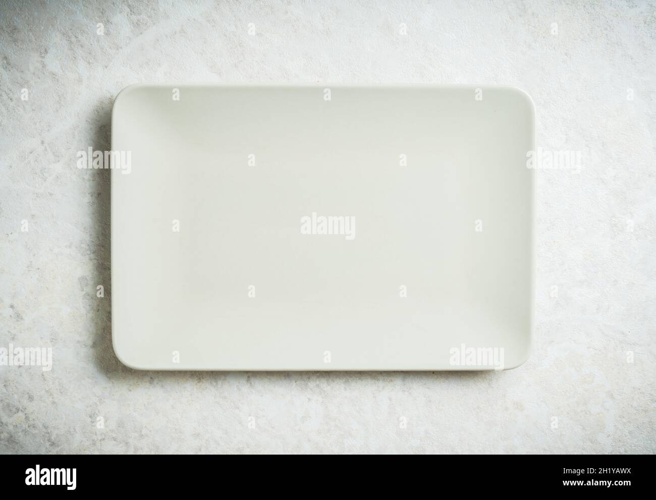 Clean light gray square plate on the white background. Selective focus ...