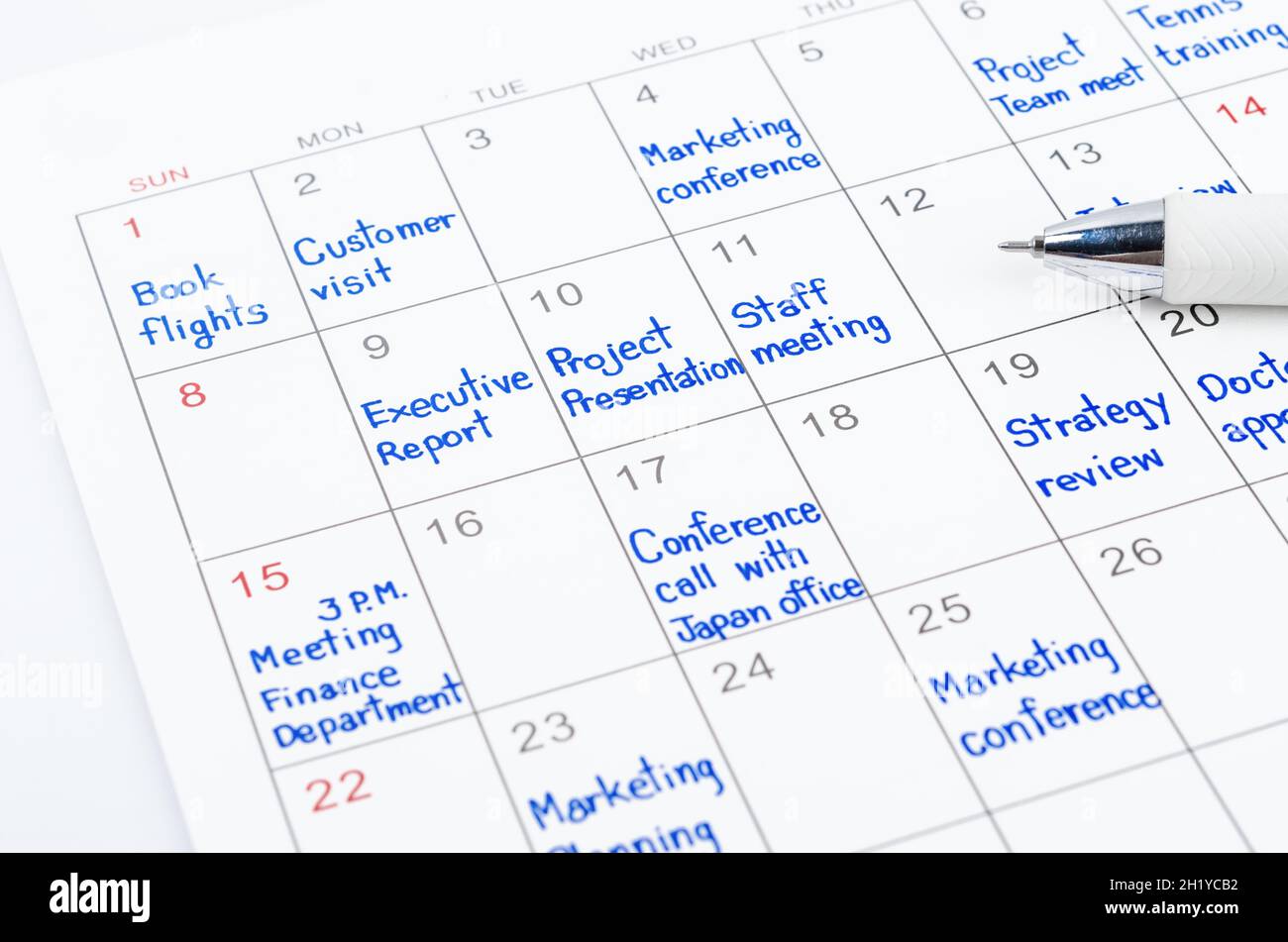 Handwriting scheduling appointments on calendar sheet with pen Stock ...