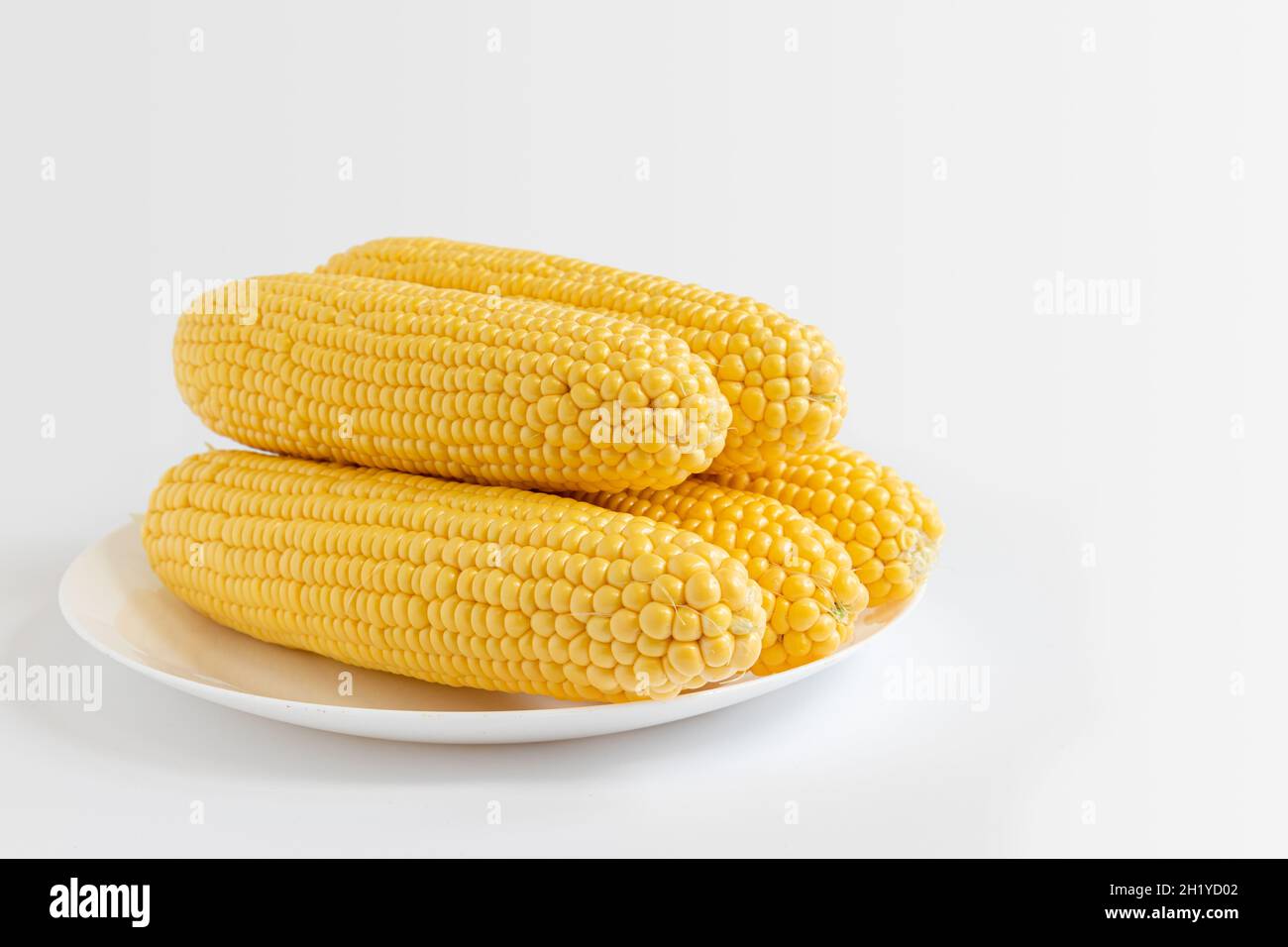 five corn cobs on plate isolated on white background, corn dish ...