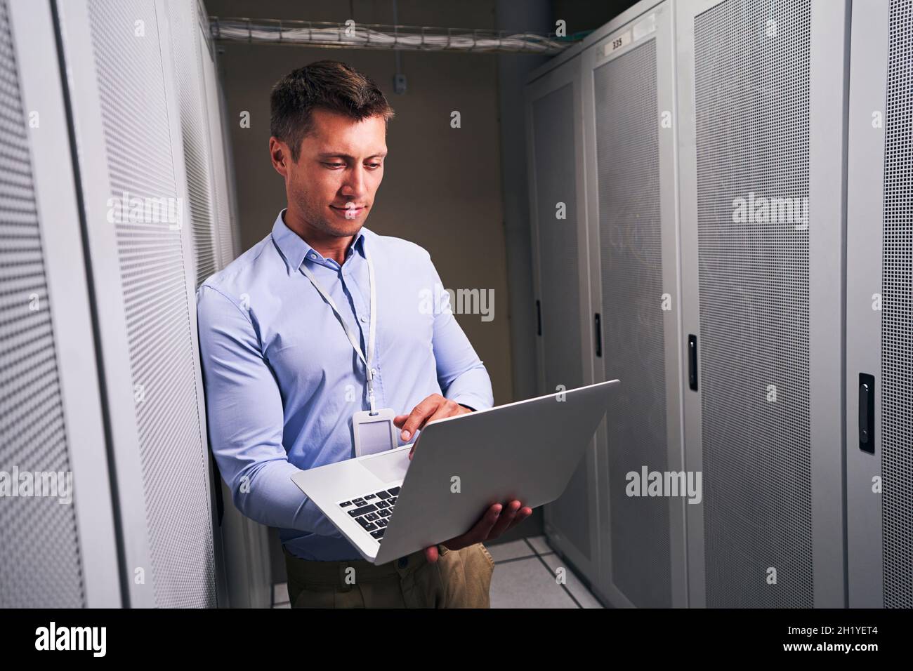 Colocation center employee entering data into laptop Stock Photo - Alamy