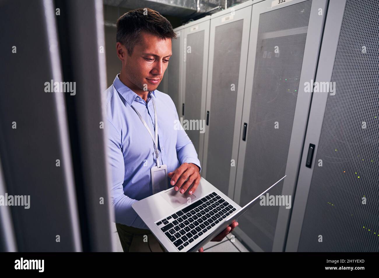 Data center employee using his notebook computer Stock Photo - Alamy