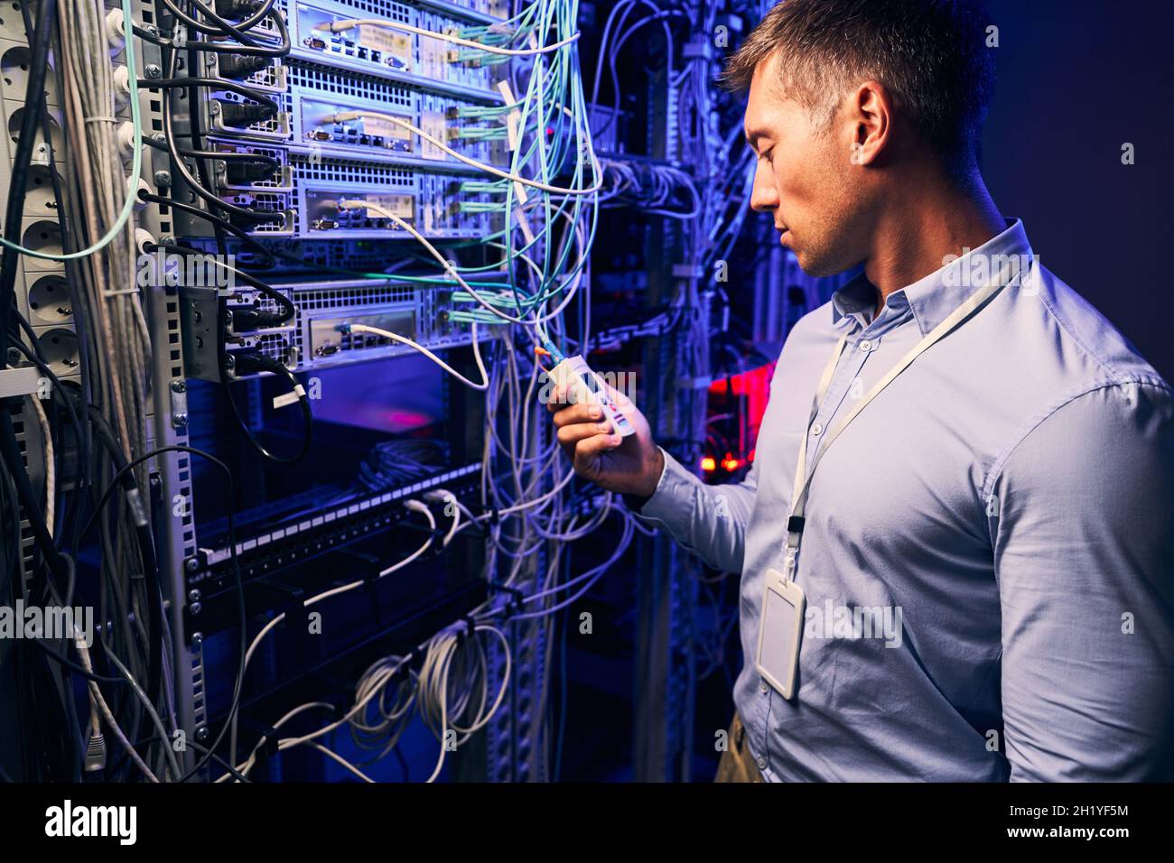Focused engineer tracing faults on network cables Stock Photo - Alamy