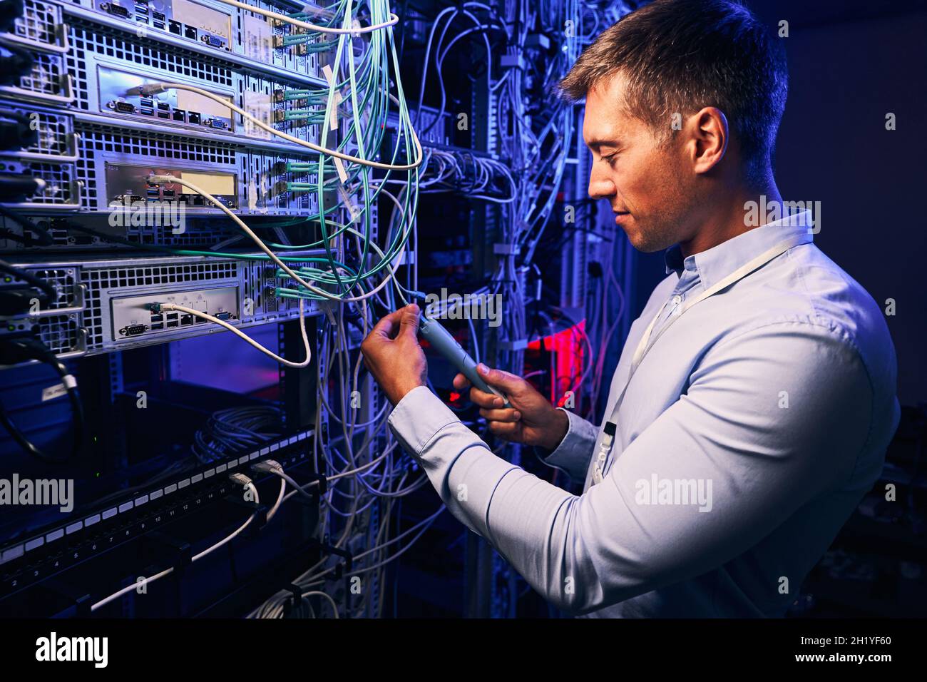 Focused data center employee checking cabling infrastructure Stock ...