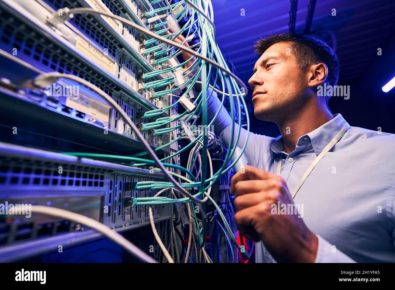 Engineer testing cable connections on network server Stock Photo - Alamy
