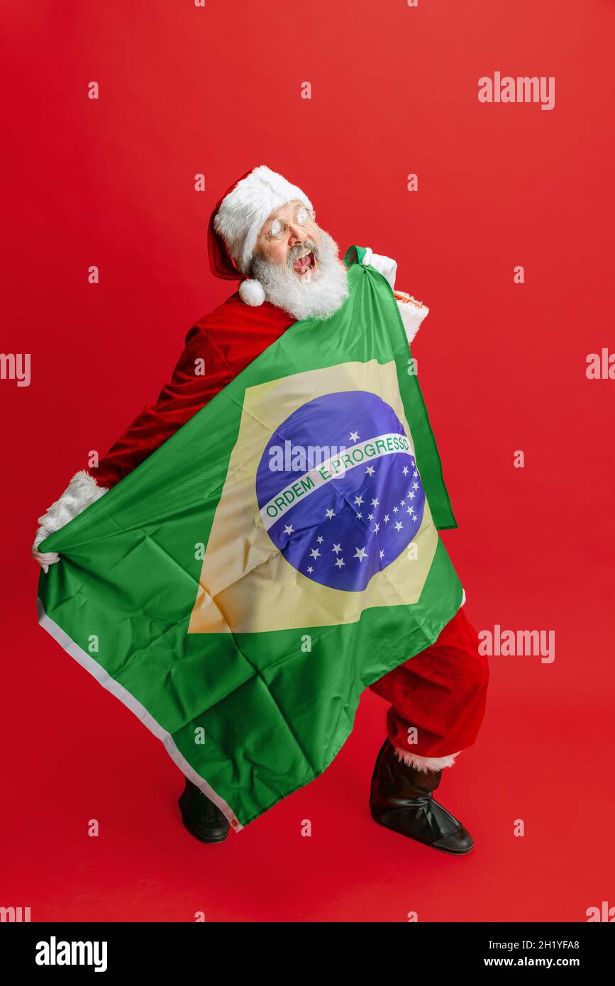 Full-length portrait of senior man wearing Santa Claus costume, holding ...
