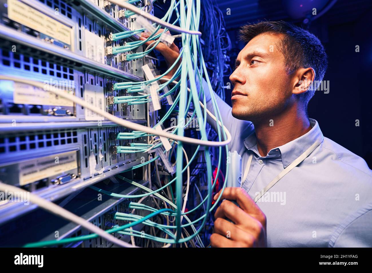 Technician monitoring fiber optic cables with electronic device Stock ...