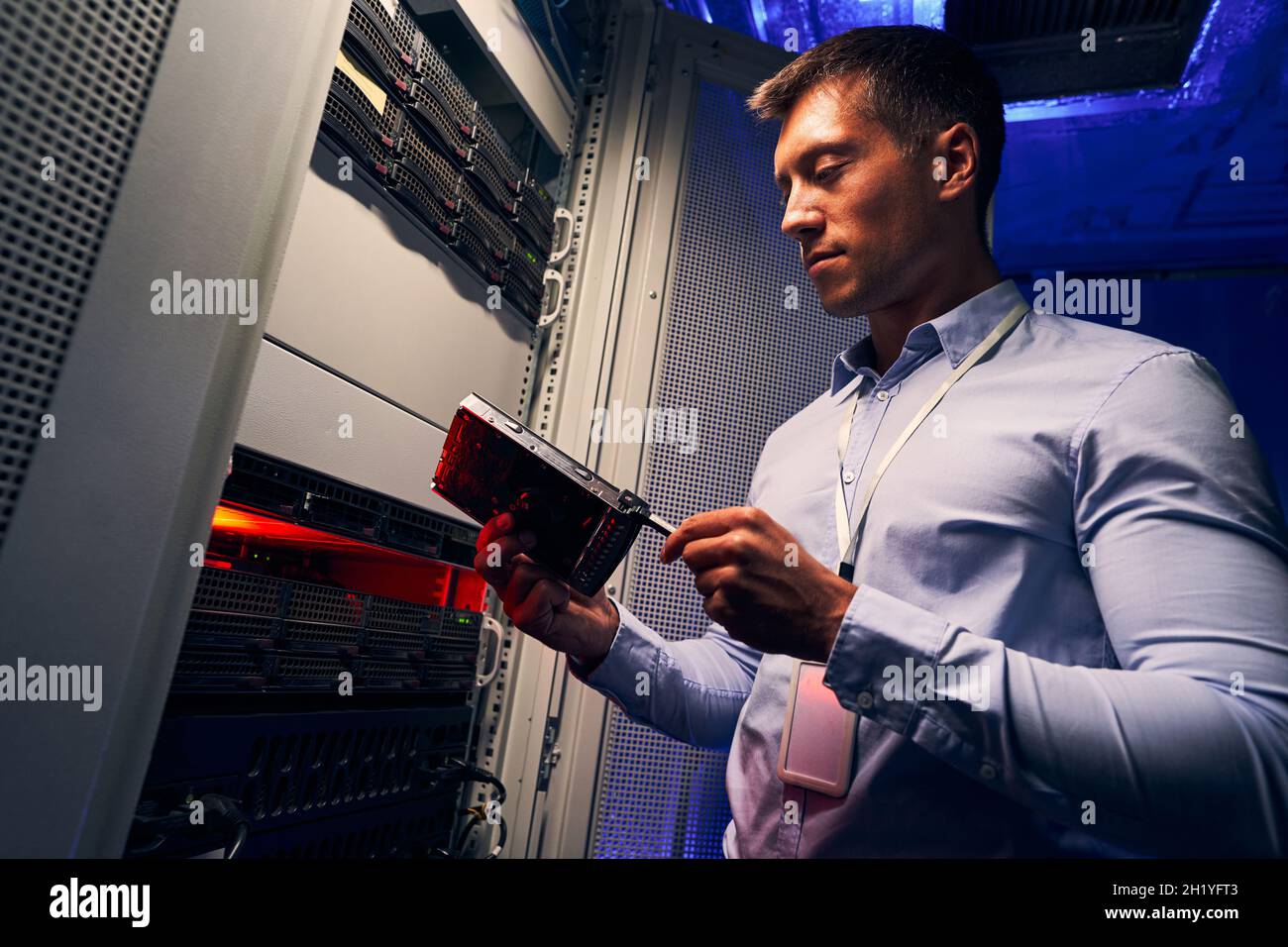 Data center engineer inspecting new hard disk drive Stock Photo - Alamy