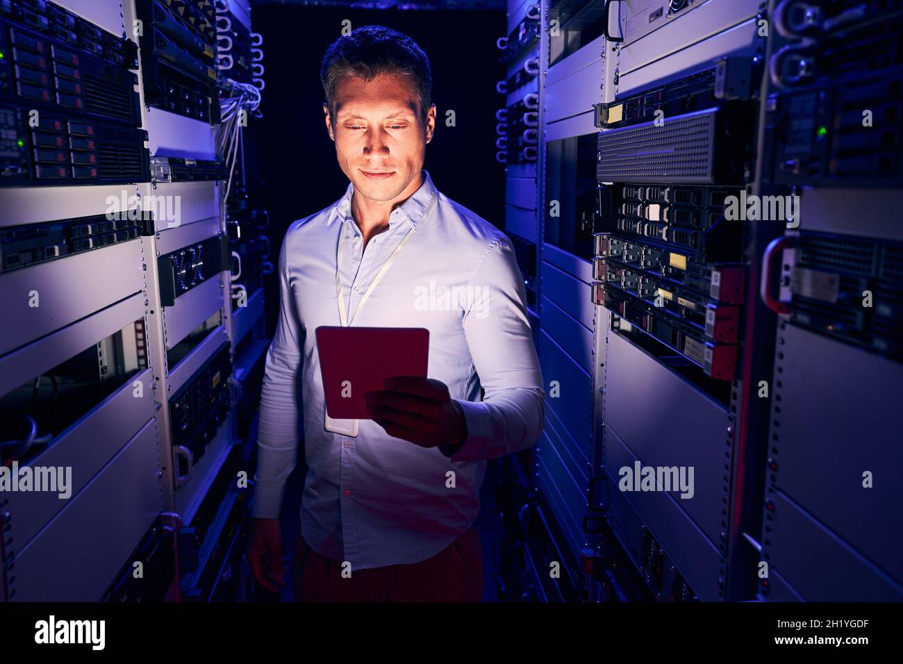 Focused IT engineer with gadget in server room Stock Photo - Alamy