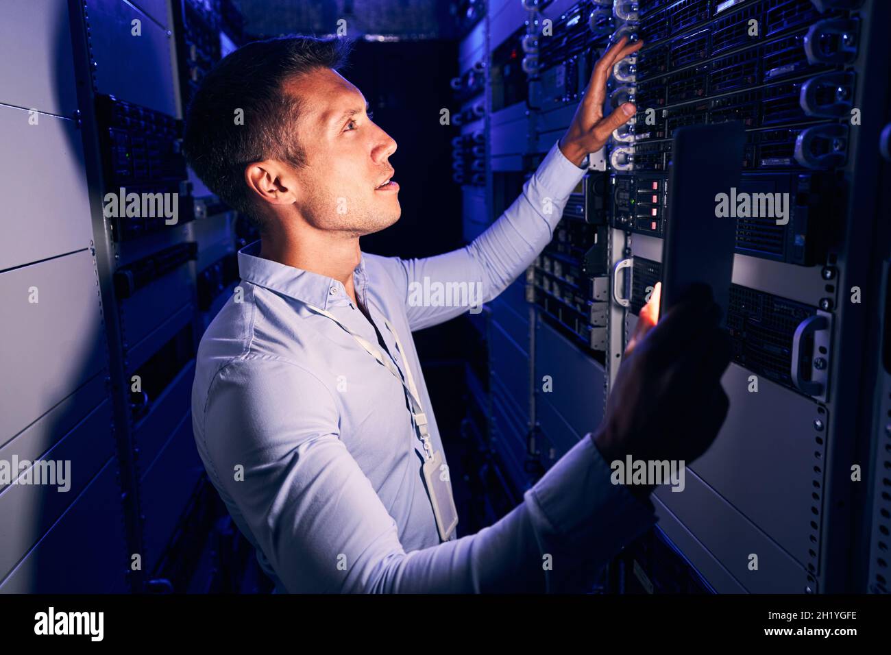 System administrator inspecting storage hardware in server room Stock ...