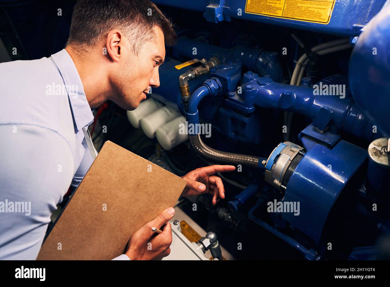 Concentrated experienced maintenance engineer examining diesel ...