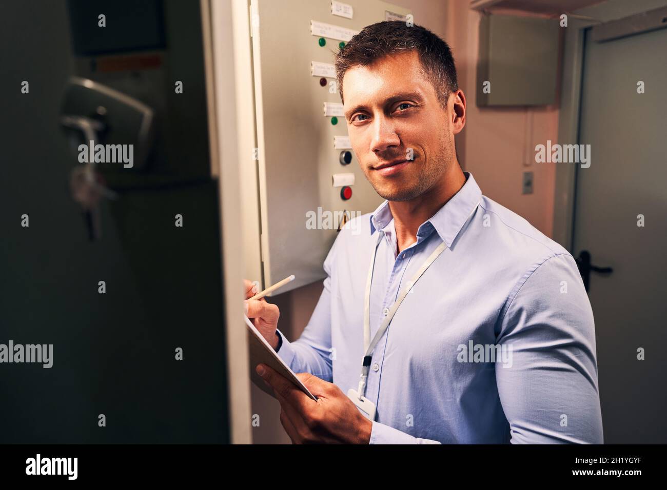Pleased maintenance engineer posing for camera at work Stock Photo - Alamy