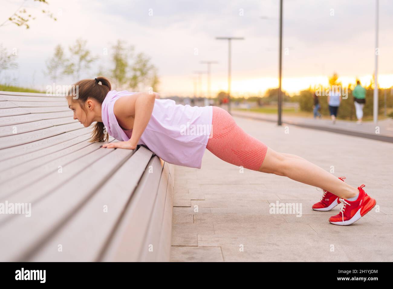 Side view of young sportive woman wearing activewear training doing ...