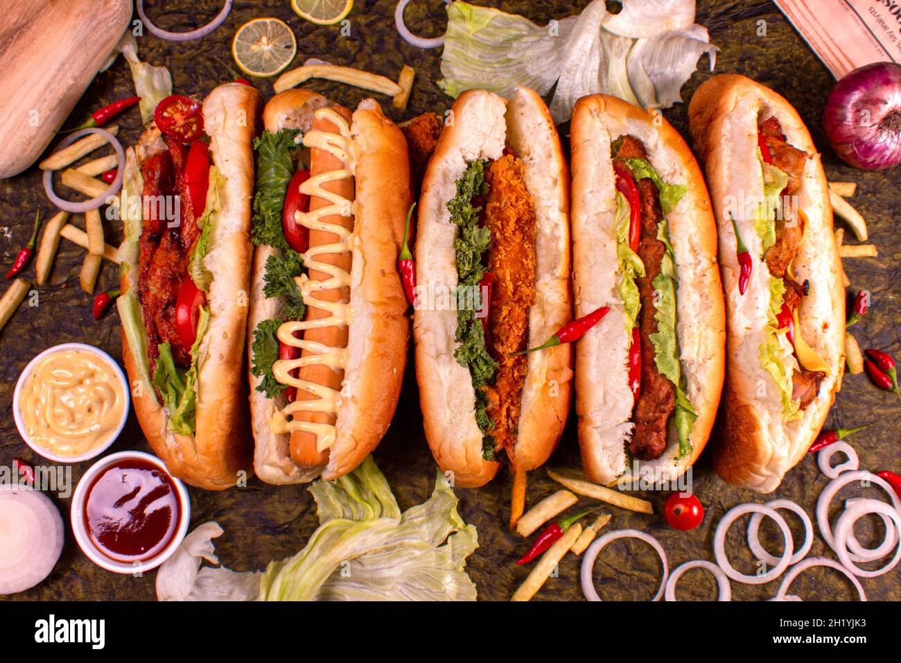 different variety of chicken rolls or wrap on wooden plate and black ...