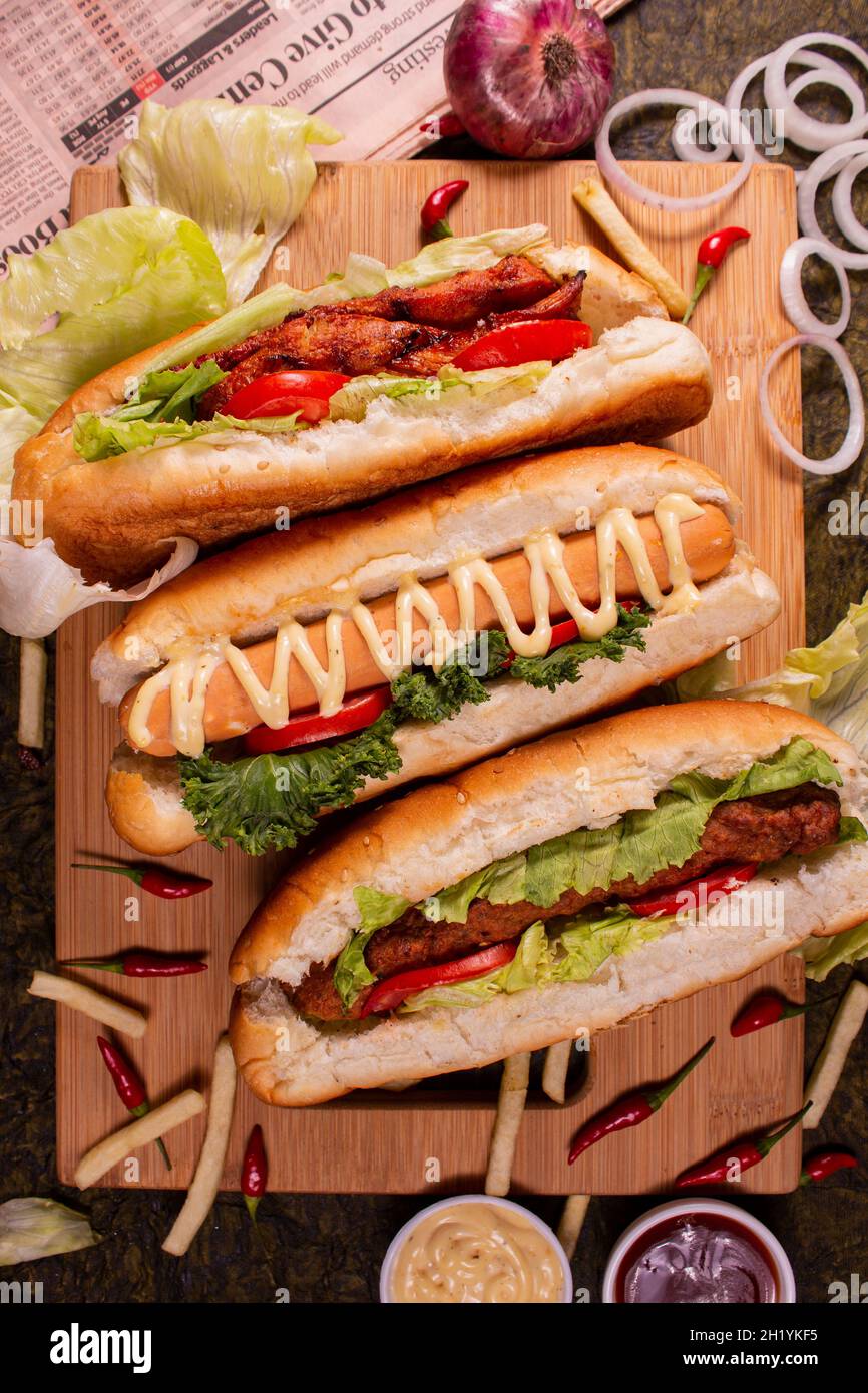 different variety of chicken rolls or wrap on wooden plate and black ...