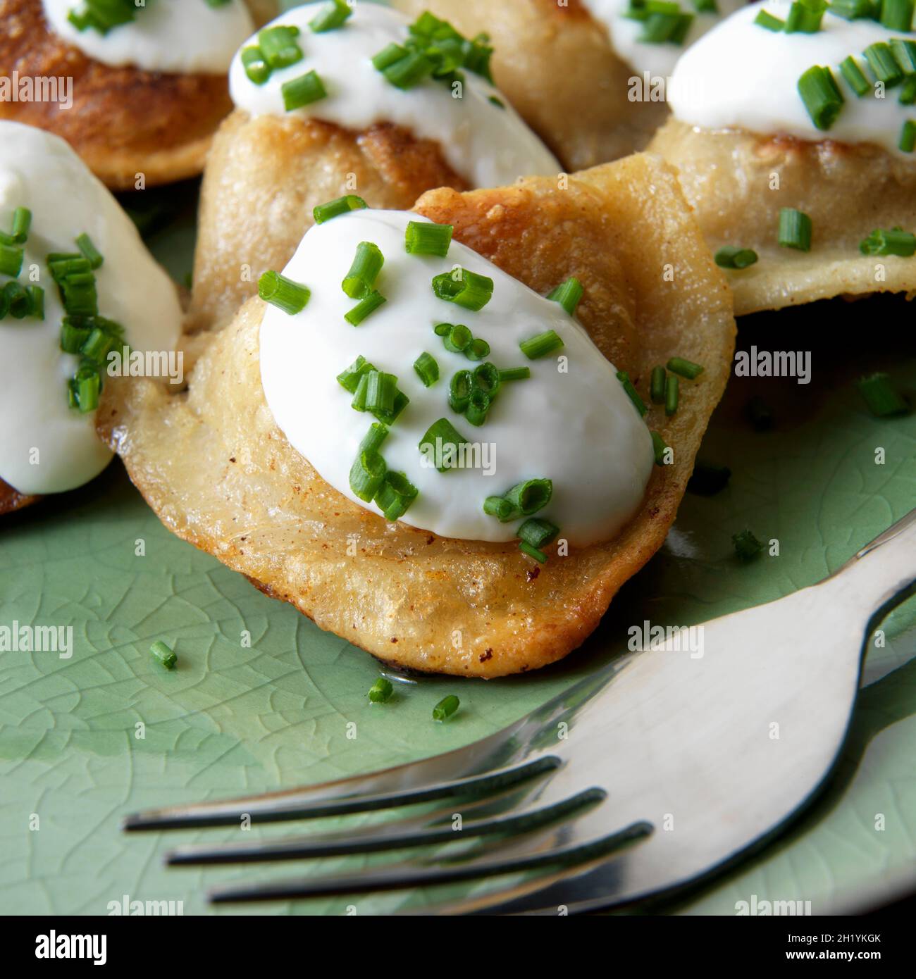 Potato filled pierogies (Pirogi) with sour cream and chives clos Stock ...