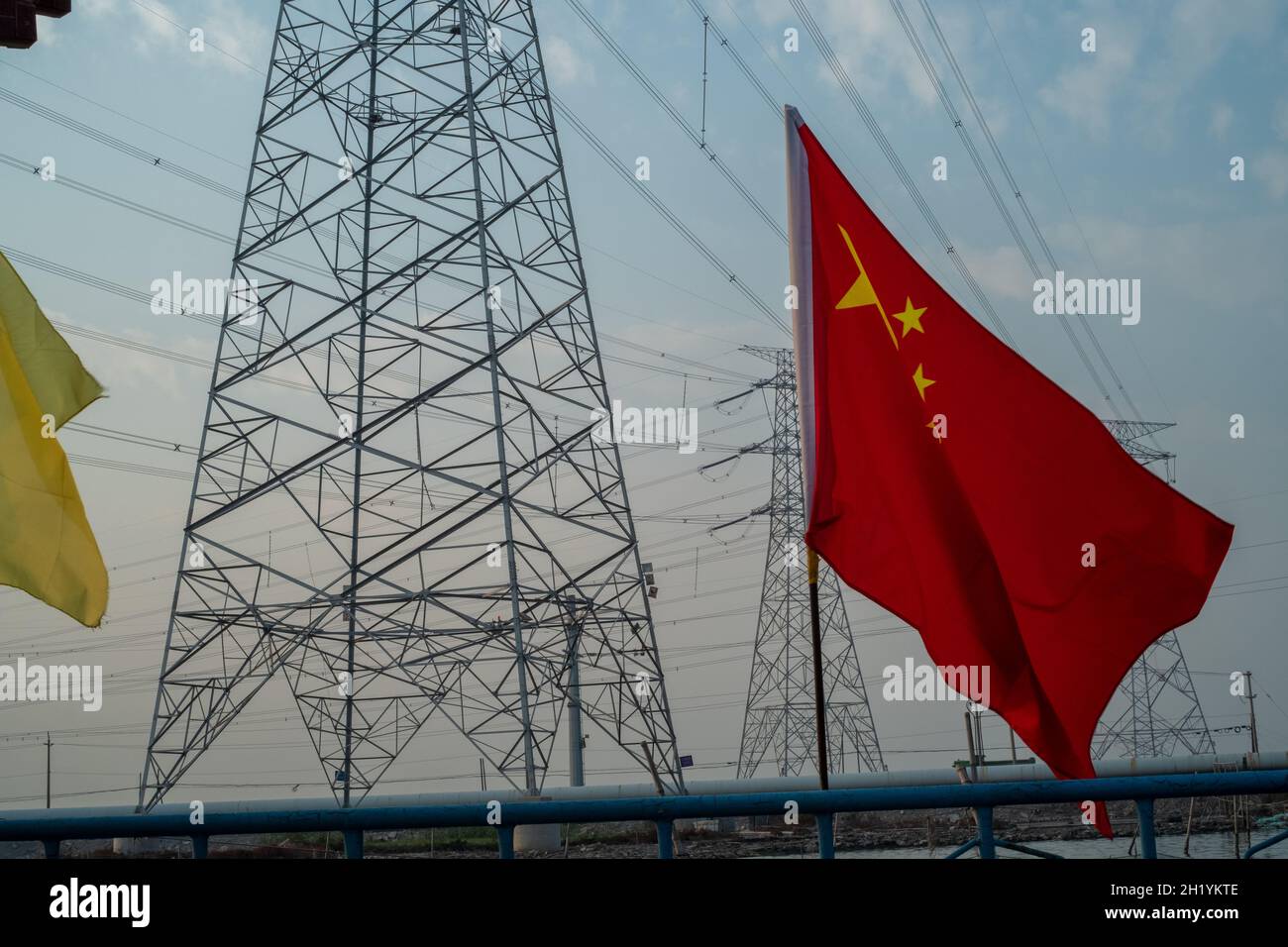 Chinese flag waving in front of high-voltage transmission towers in ...