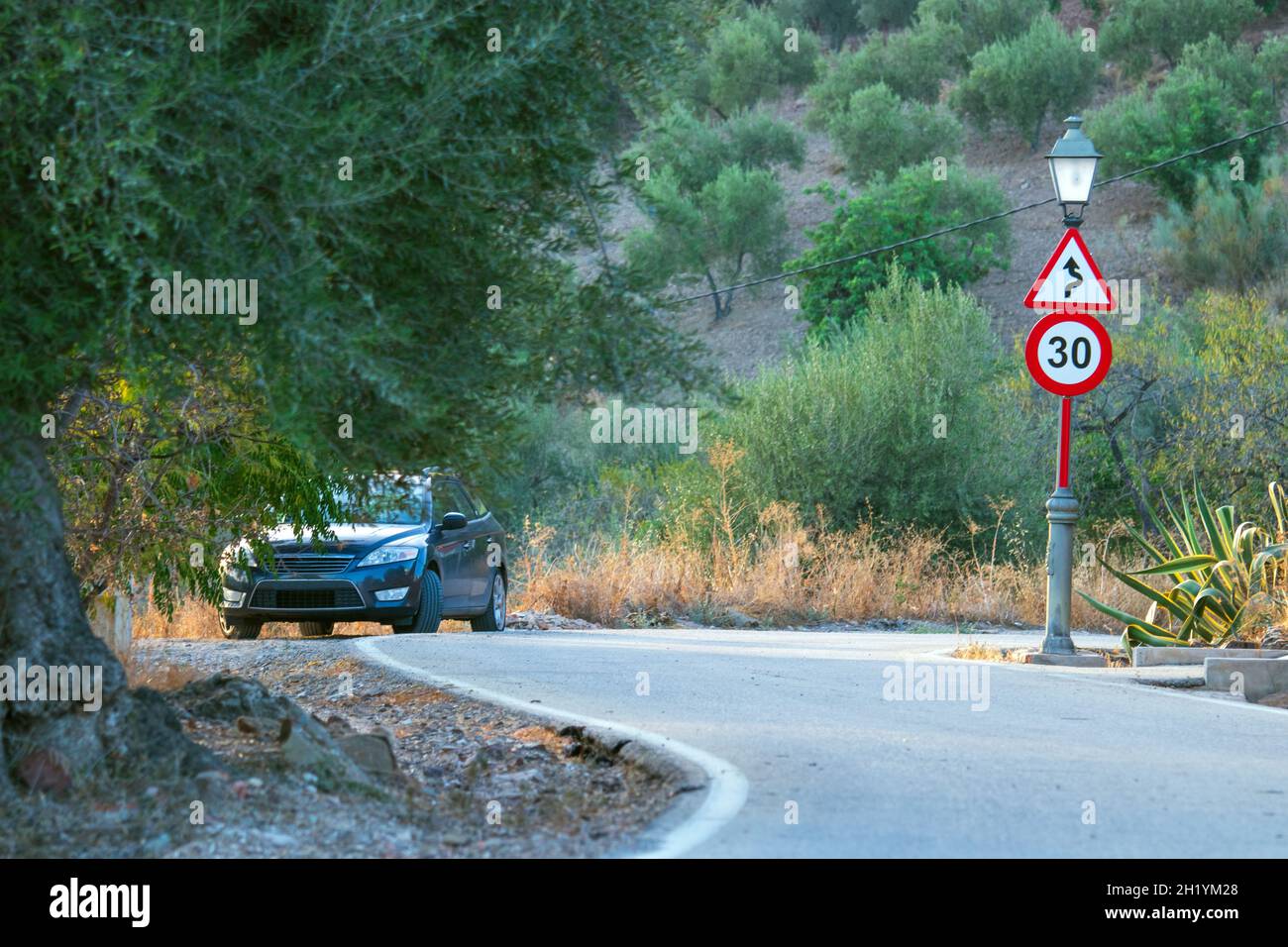 Car on a road that bends in opposite direction, traffic sign Stock ...