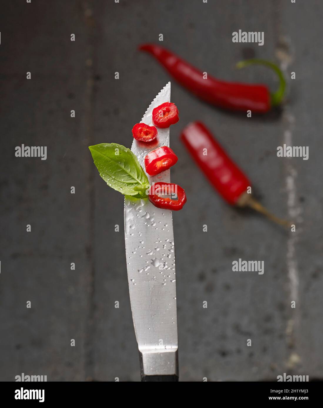 Red chilli rings on a knife tip with water droplets Stock Photo - Alamy