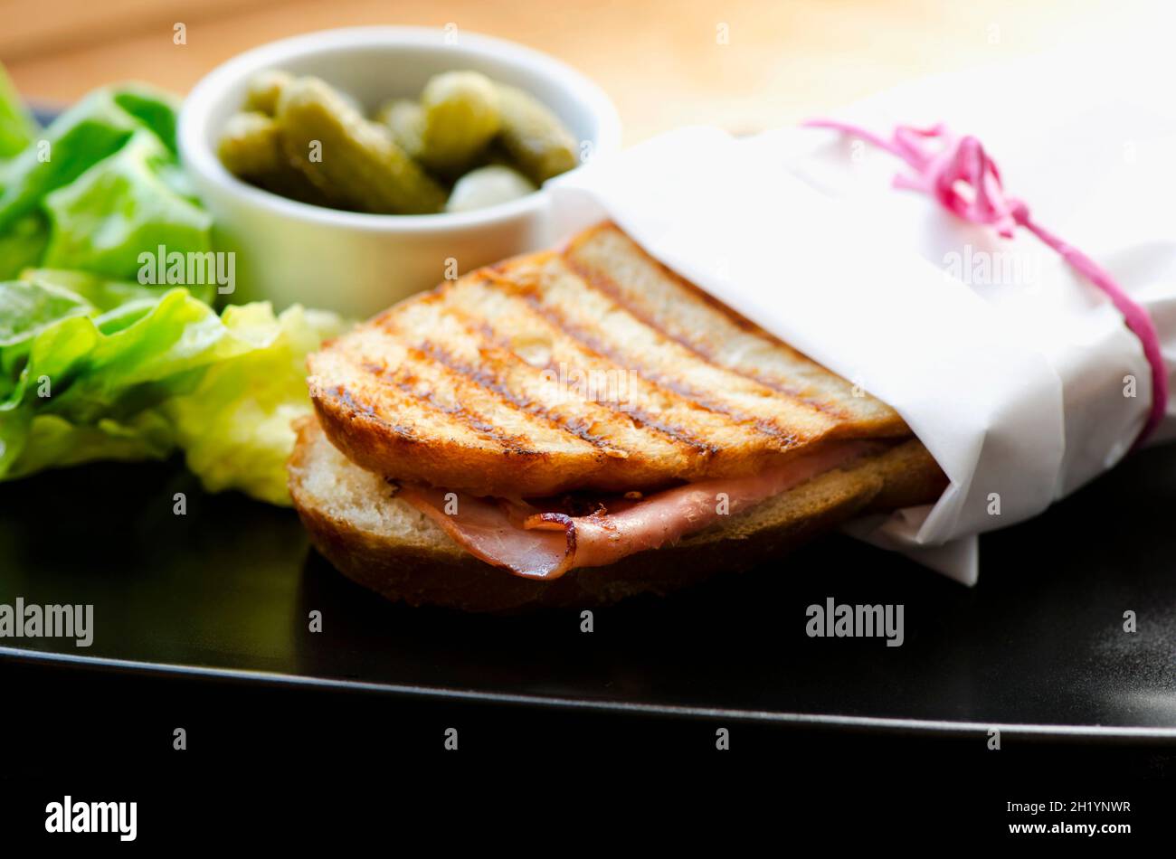 A ham and cheese panini wrapped in paper Stock Photo - Alamy