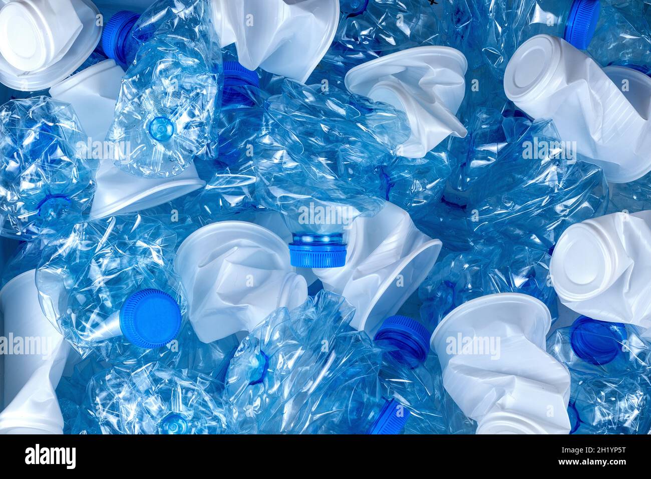 Plastic waste materials laid on green isolated background. waste ...