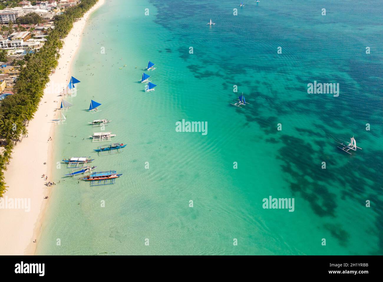 Beautiful lagoon with boats and tourist beach. White beach on the ...