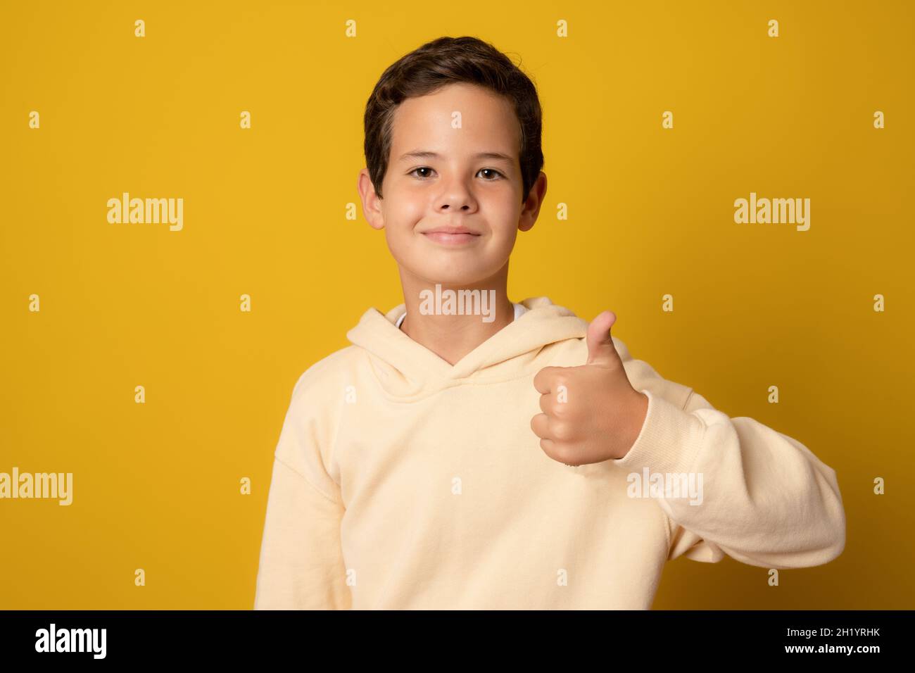 little boy isolated over yellow background smiling and raising thumb up ...