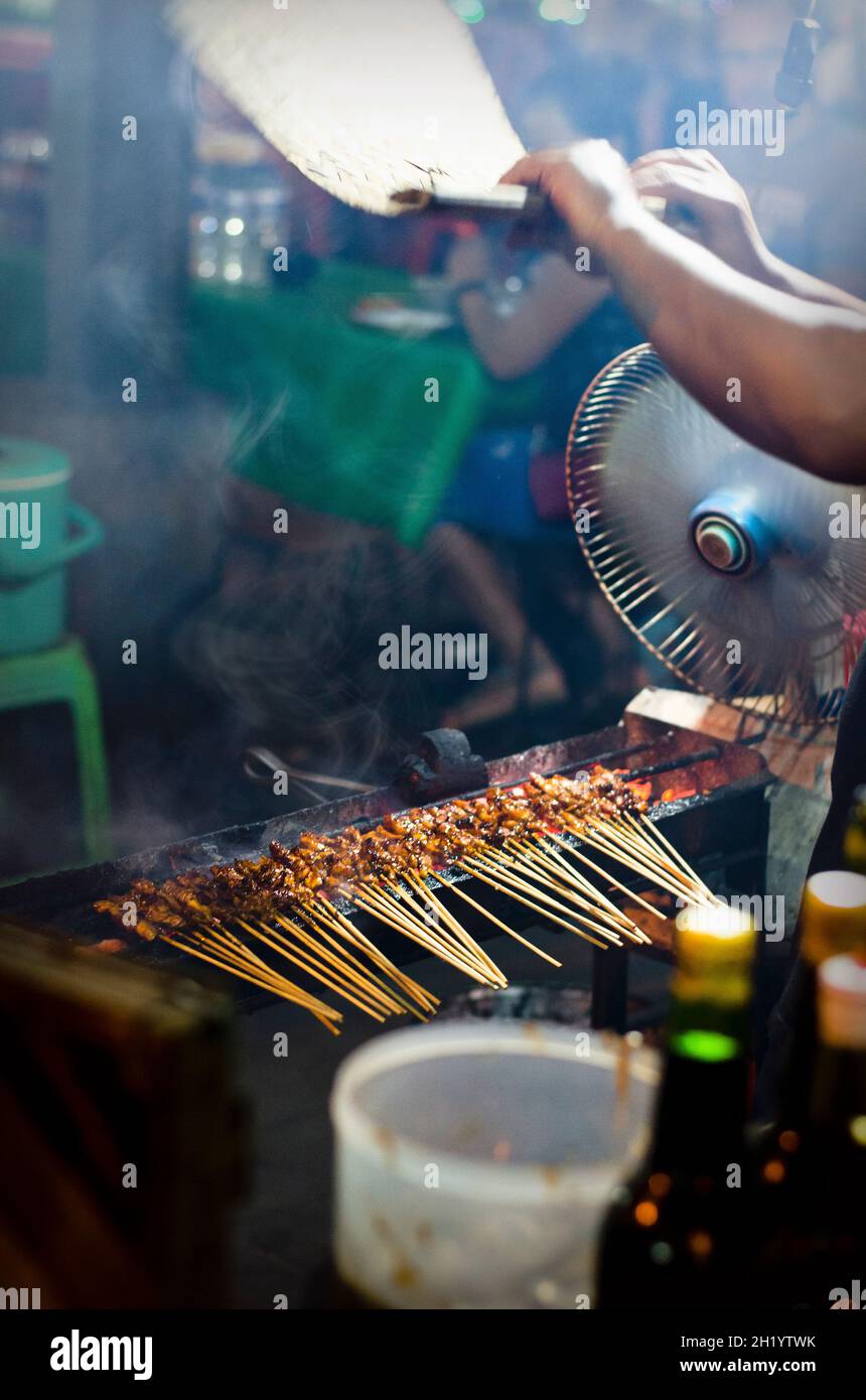 Satay sticks on the grill being fanned at a market in Bali Stock Photo ...
