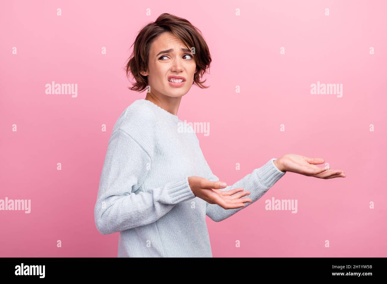 Photo of unhappy upset clueless young woman shrug shoulders look empty ...
