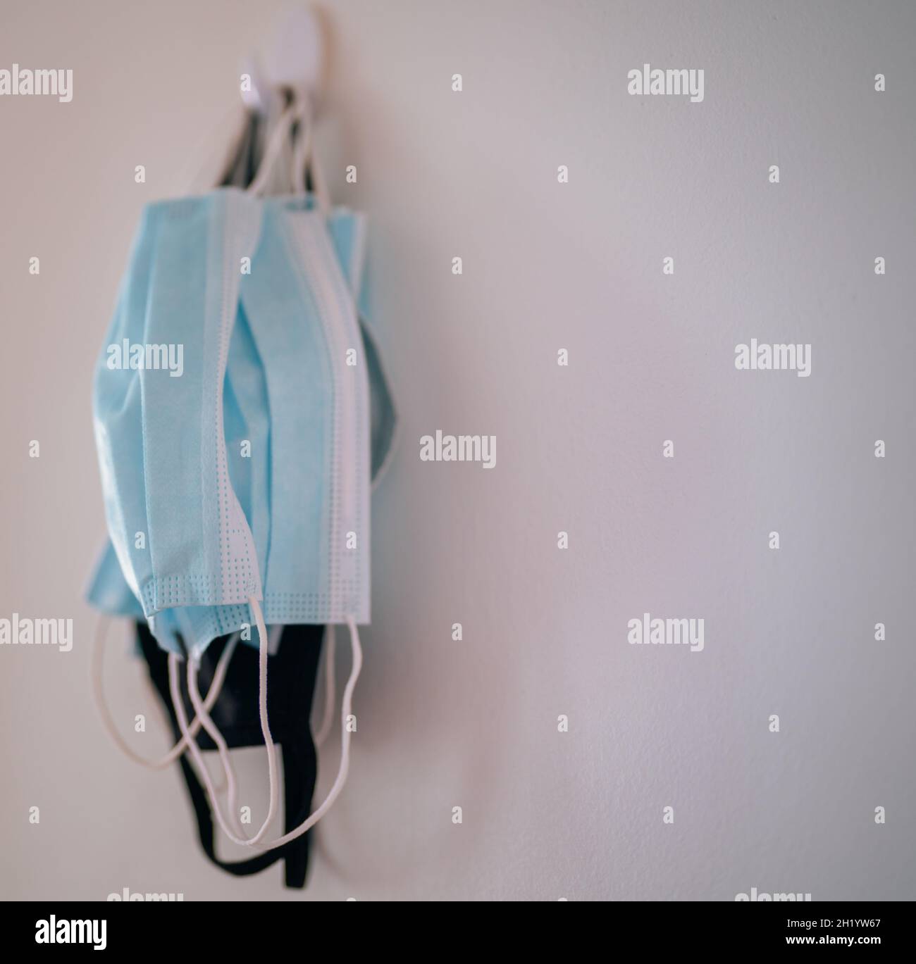 Face masks hanging on a hook on the wall; background with a copy space ...