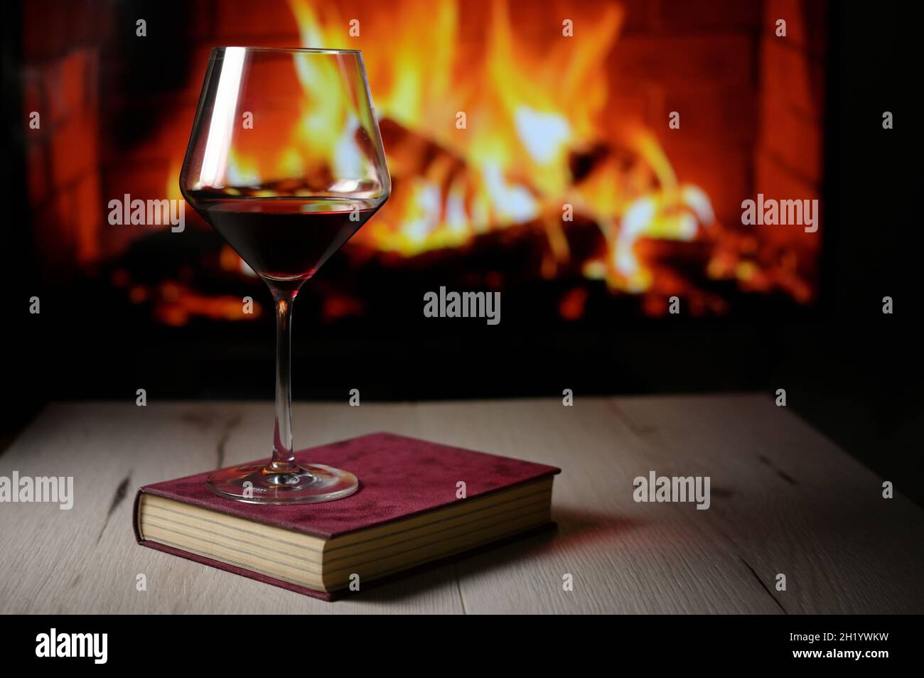 Dry Glass Of Red Wine, on Book and Fireplace in Background Stock Photo ...