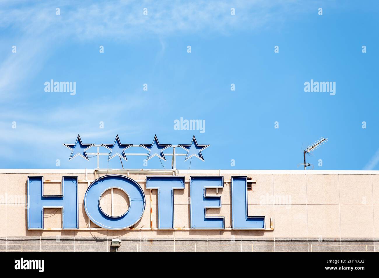 Top view of a hotel, at noon, with a sign with the neon lights off that ...