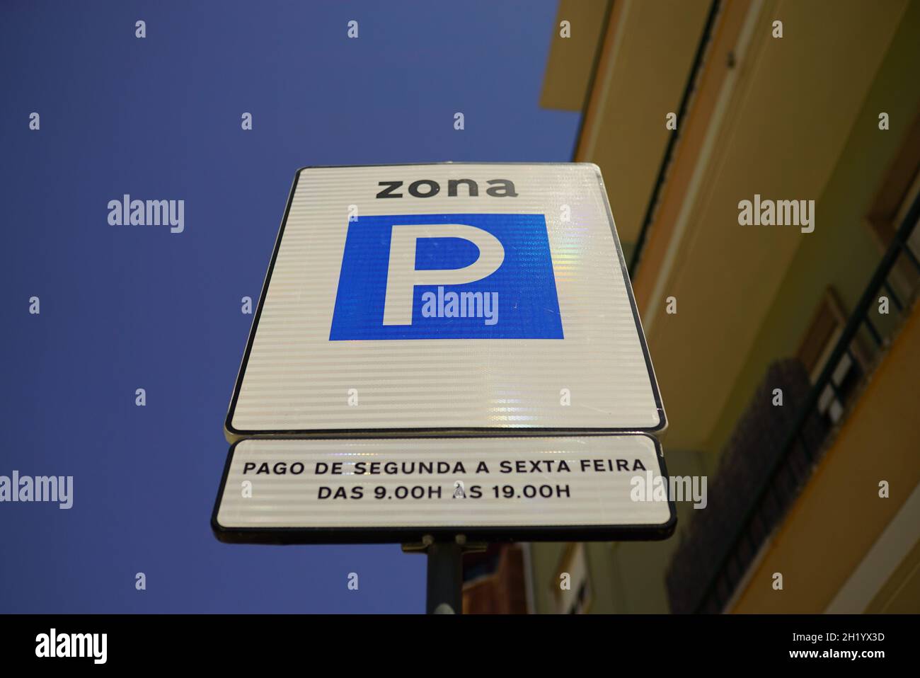 Low angle of a metallic blue parking sign on the side of the road Stock ...