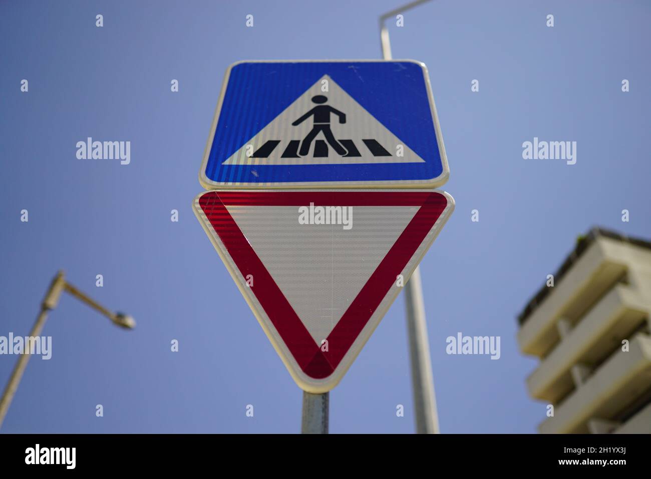 Low angle of the blue metal crosswalk sign against the blue sky on the ...