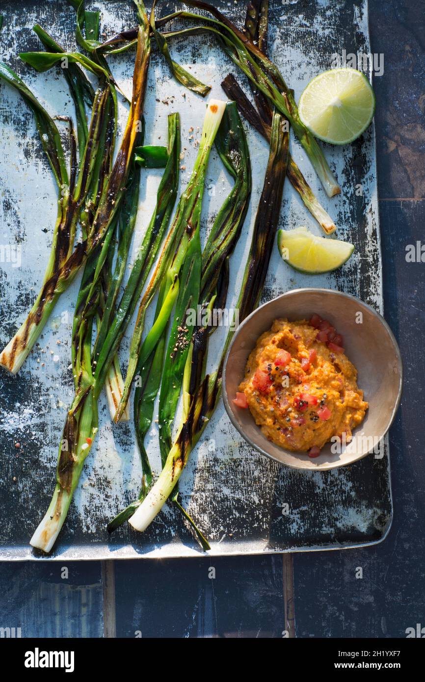 Grilled spring onions with a dip Stock Photo - Alamy