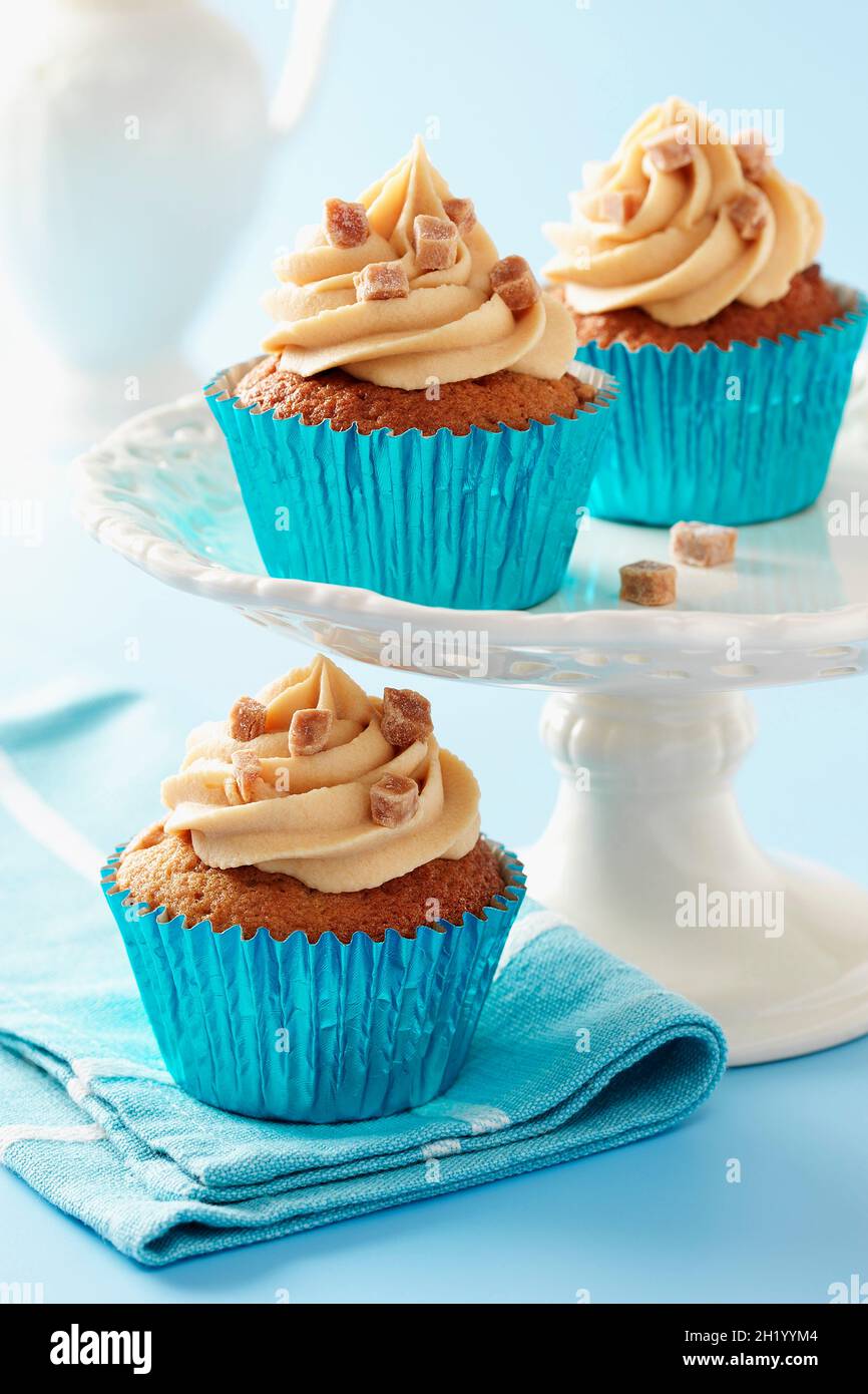 Sticky toffee cupcakes with caramel icing and fudge pieces in blue ...