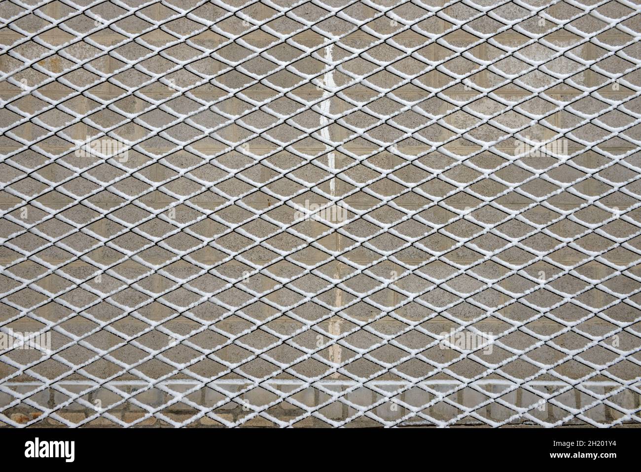 Close-up pattern of many cells of chain-link fence that are covered ...