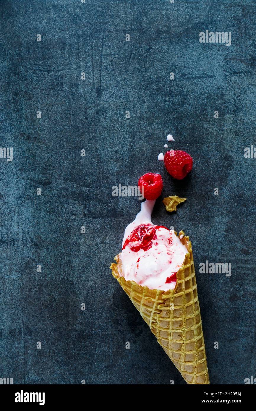Raspberry ice cream in a cone on a blue grey surface (top view Stock ...