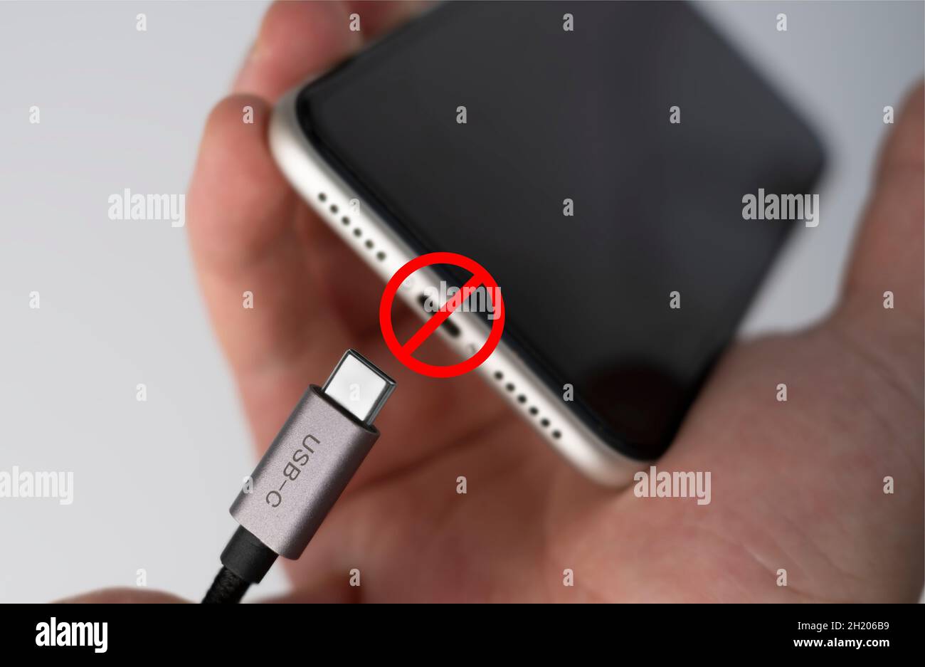 European union bans lightning cable. hand trying to plug type-c cable ...