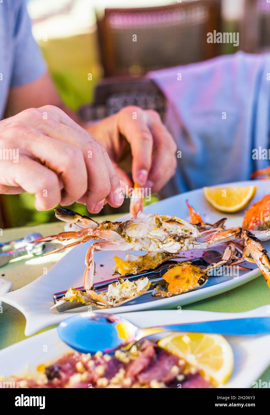 A person using their hands to eat crab Stock Photo - Alamy
