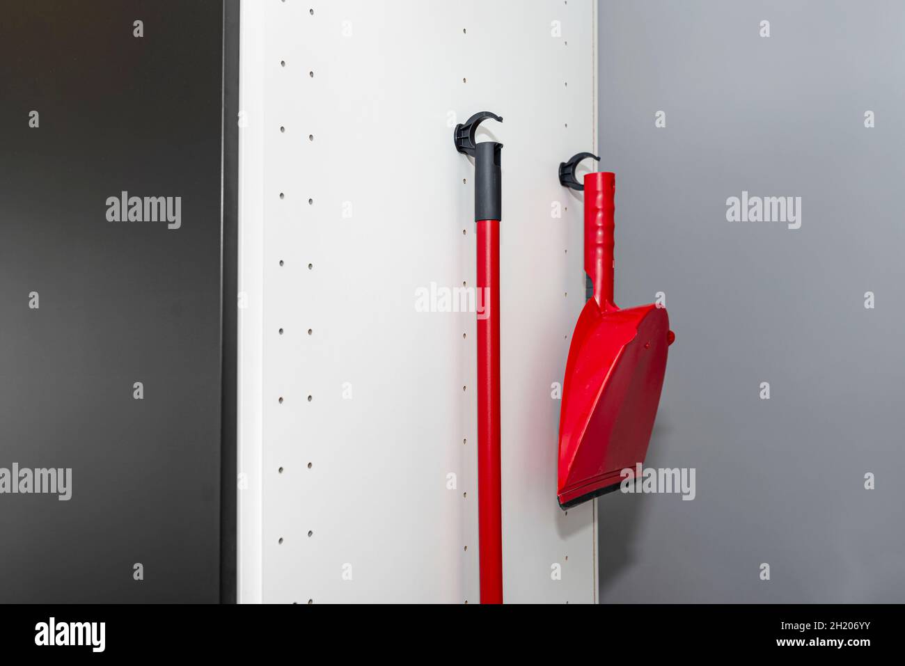 Dustpan and broom hanging in a built-in kitchen cupboard, black pantry ...