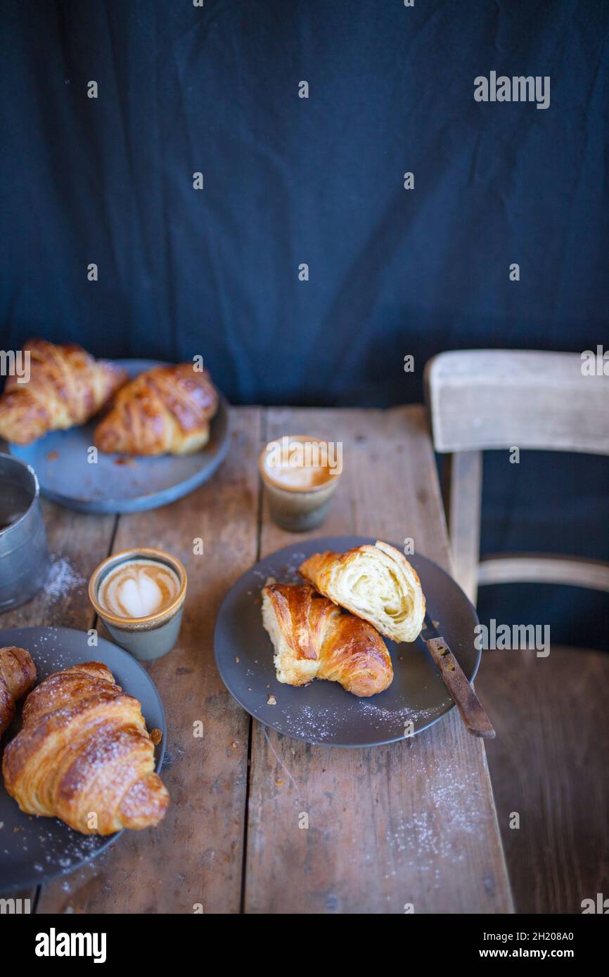 Croissants with cappuccinos on a rustic wooden table Stock Photo - Alamy