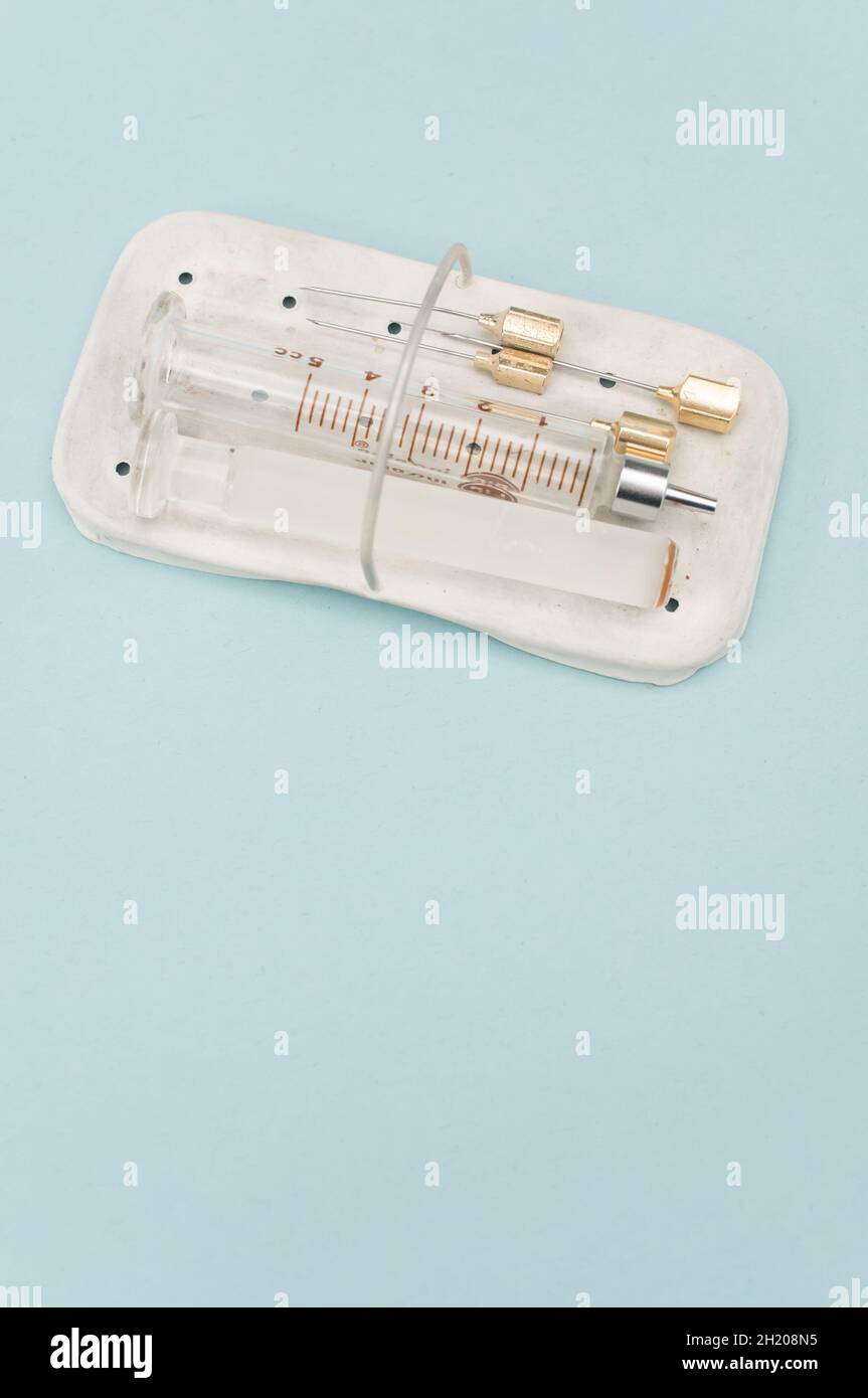 isolated sterilized glass injection syringe in a box on a blue Stock ...