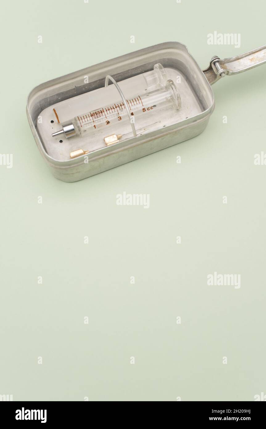isolated sterilized glass injection syringe in a box on a green ...