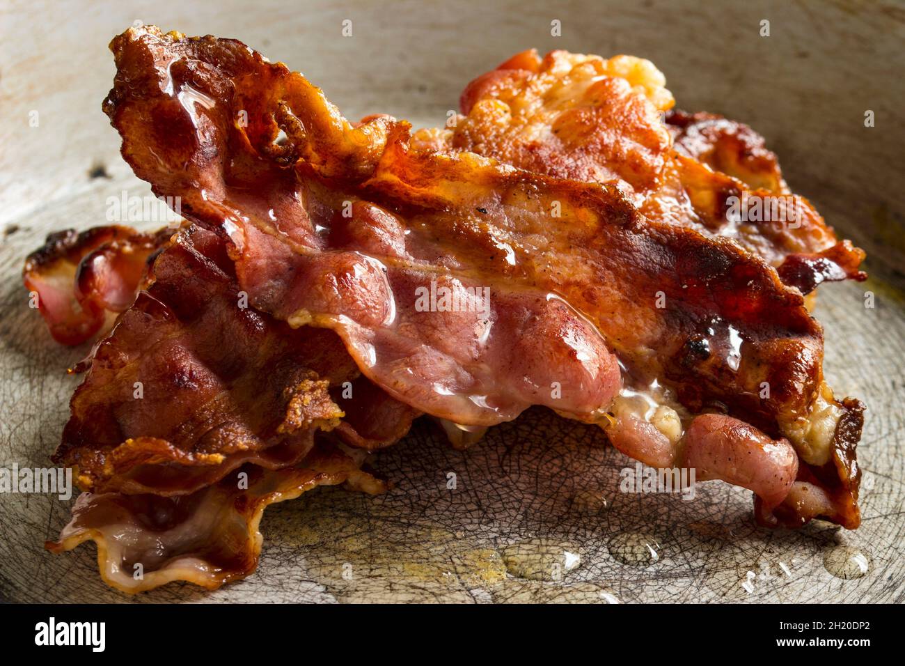 A stack of crispy rashers of bacon in a pan Stock Photo - Alamy