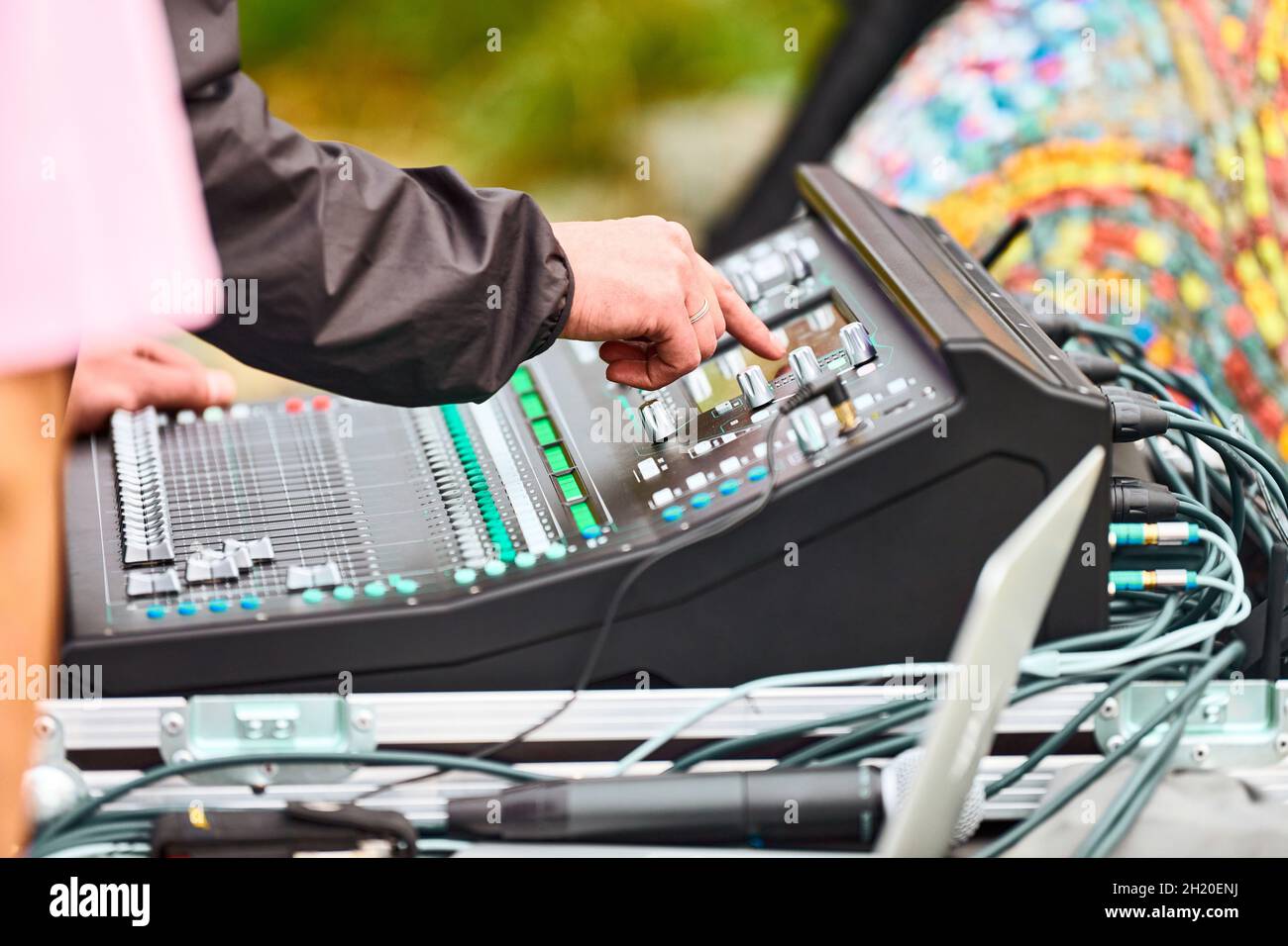 Sound engineer hand adjusting audio mixer at live concert outdoor ...