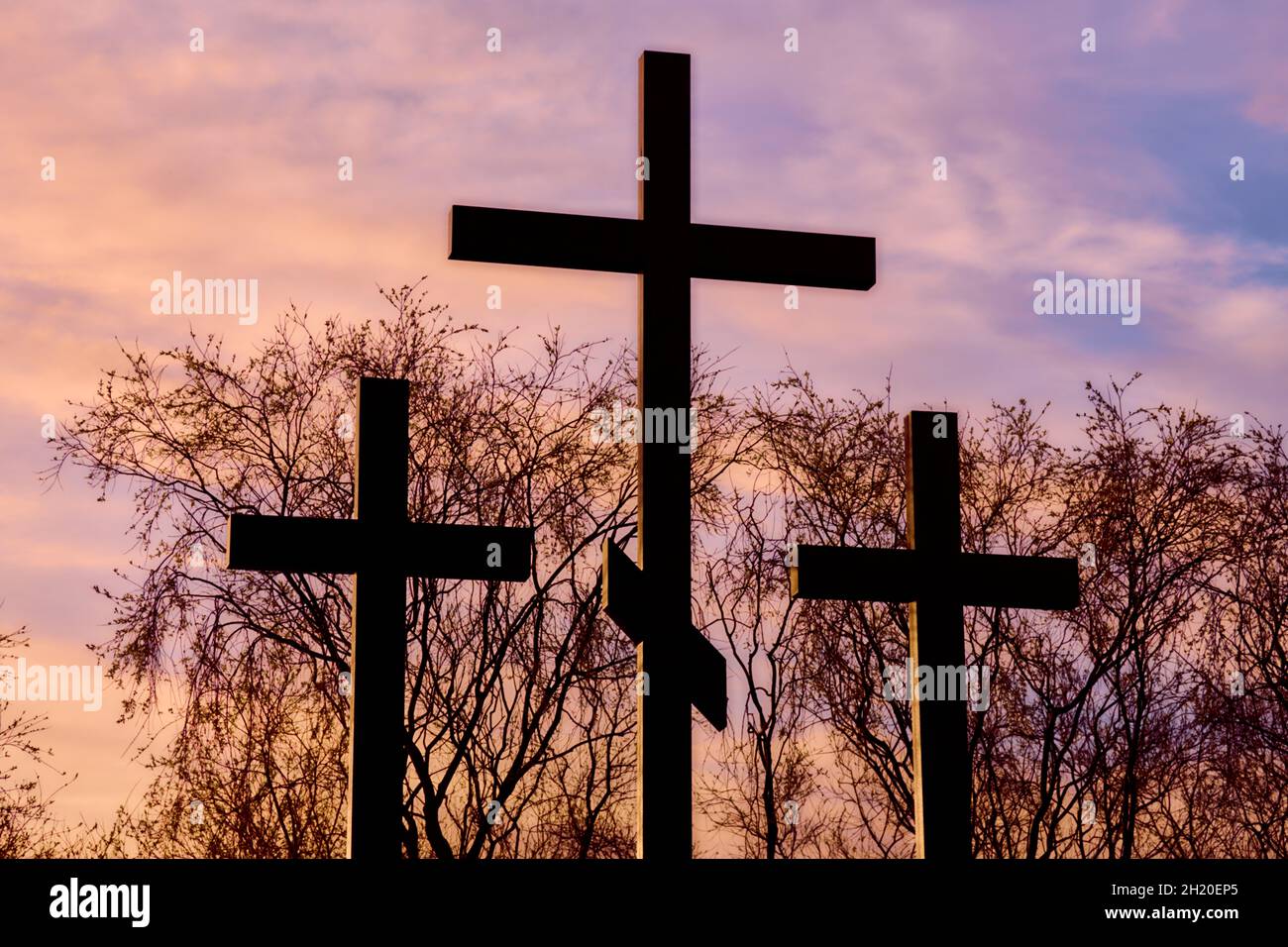 Three crosses in silhouette at sunset, dramatic sky background ...