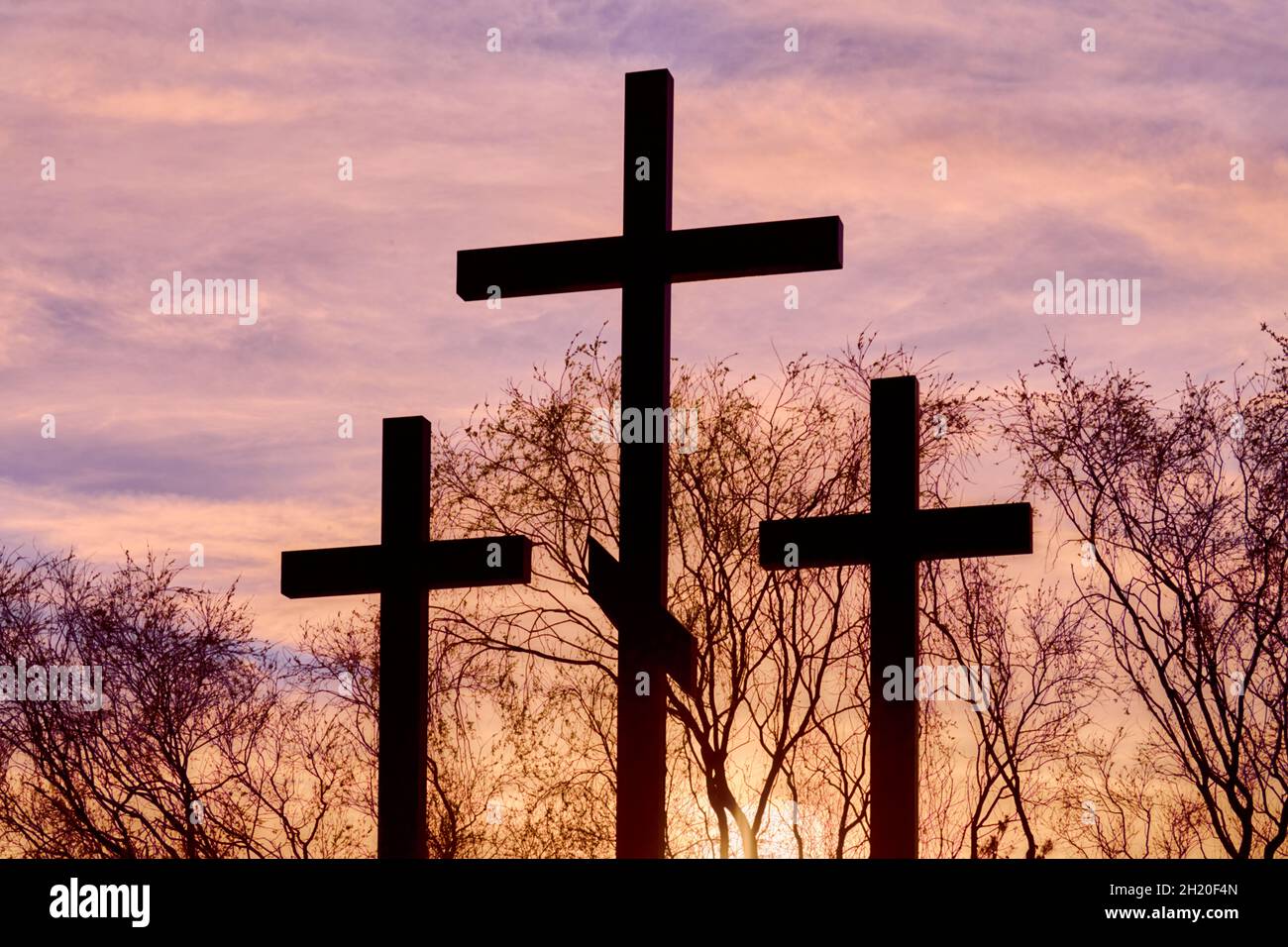 Three crosses in silhouette at sunset, dramatic sky background ...