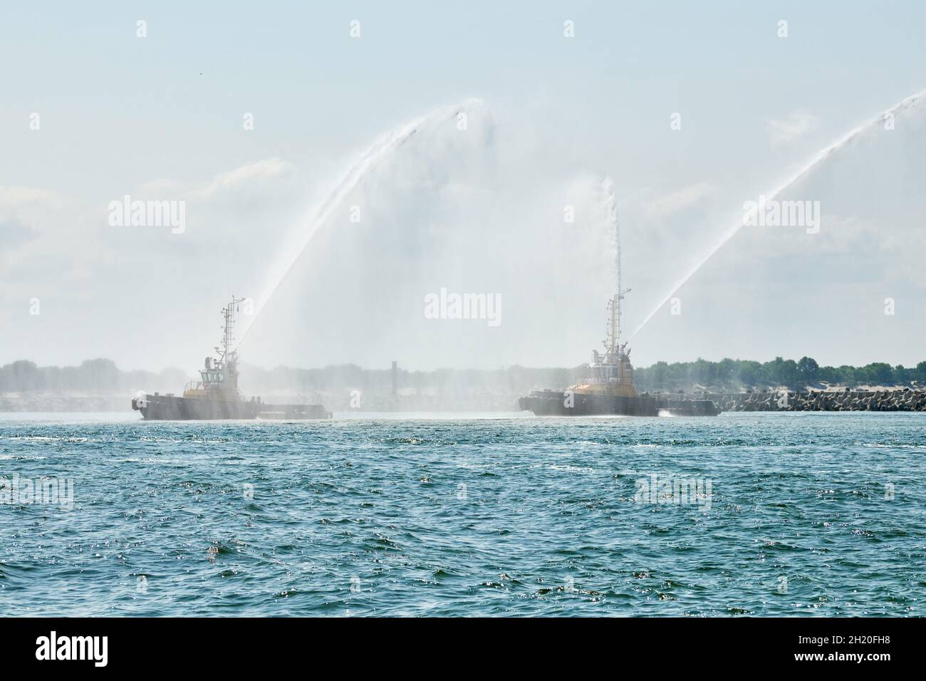 Floating tug boats spraying jets of water, demonstrating firefighting ...